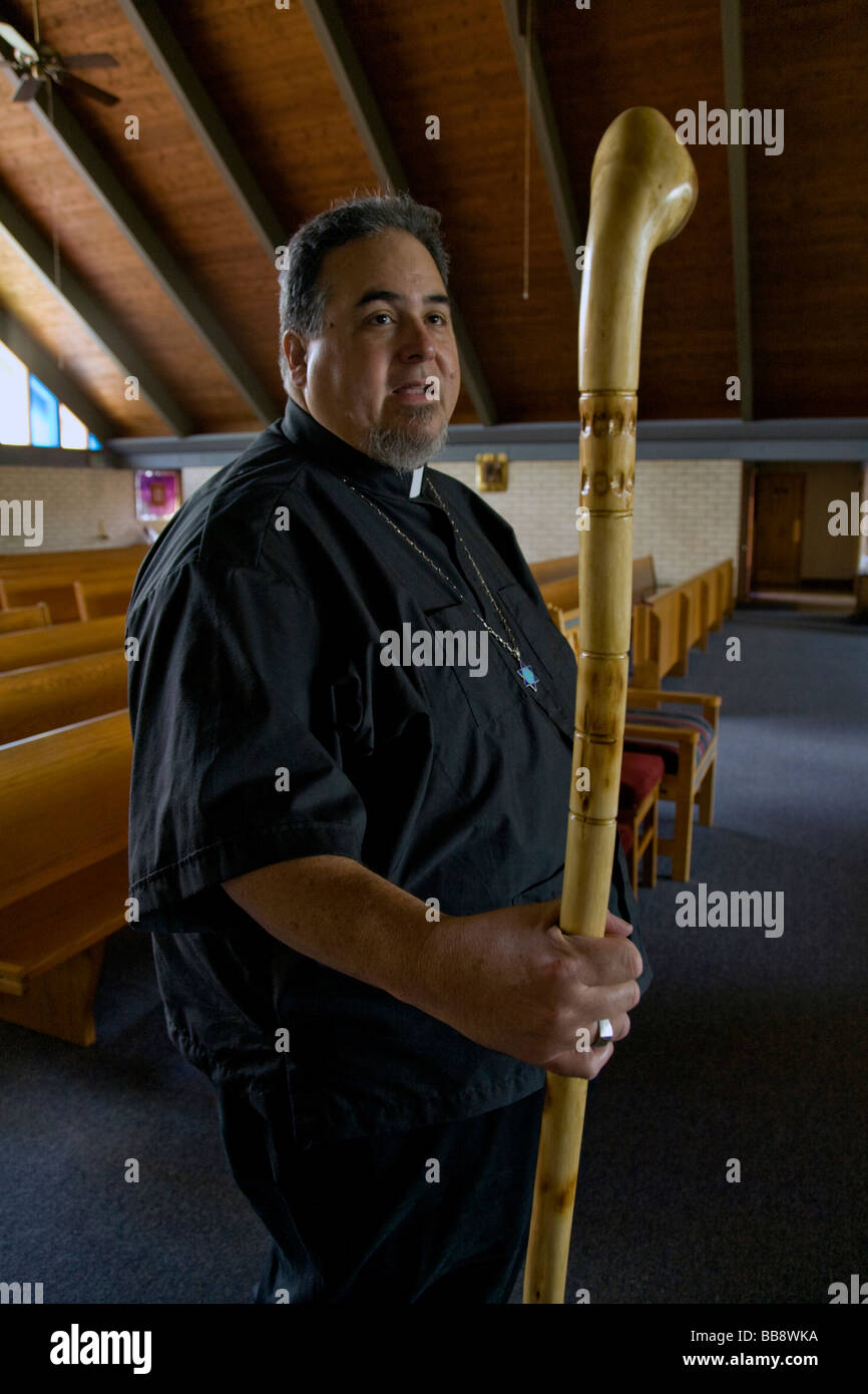 Hispanic priest with a Staff of Aaron at the alter of his Catholic ...