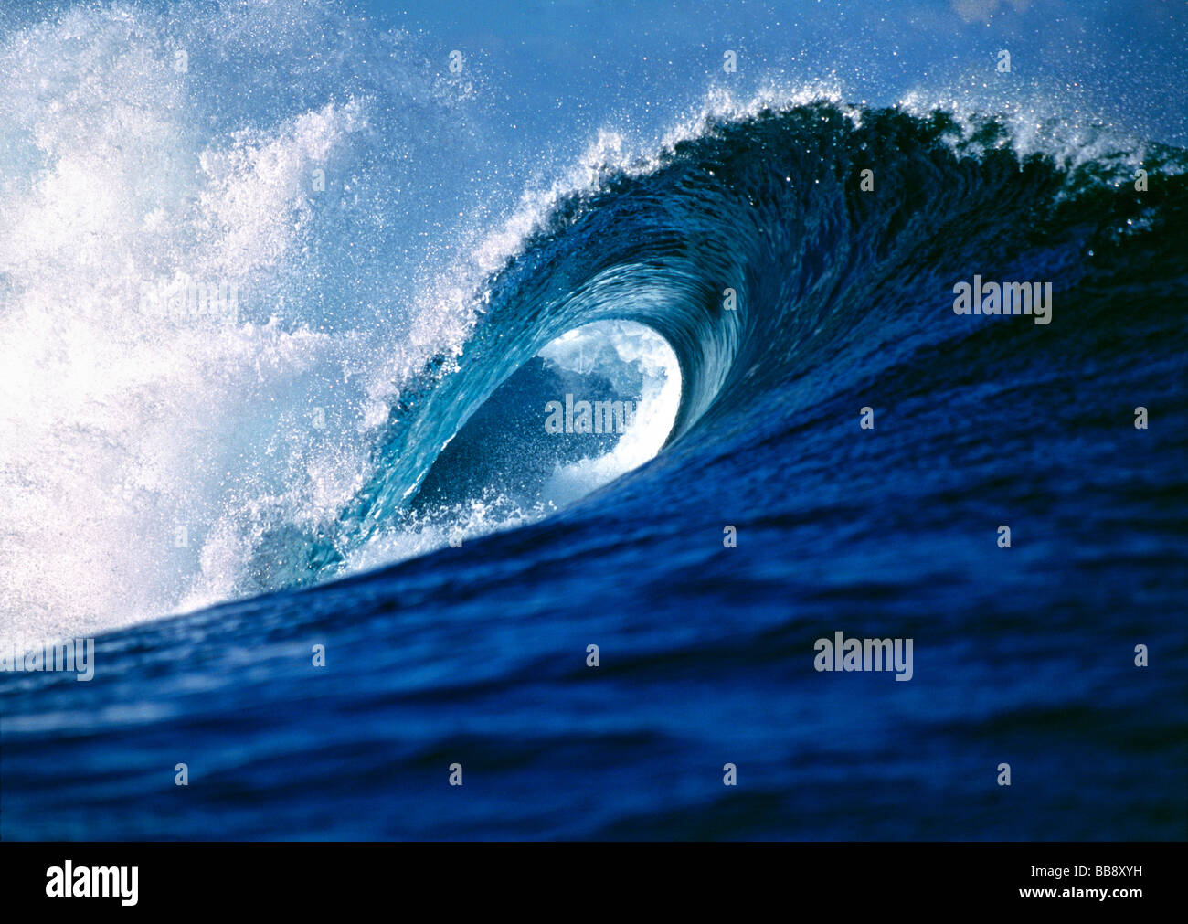 A wave creates a perfect curl at Cloudbreak near Tavarua Fiji Islands ...