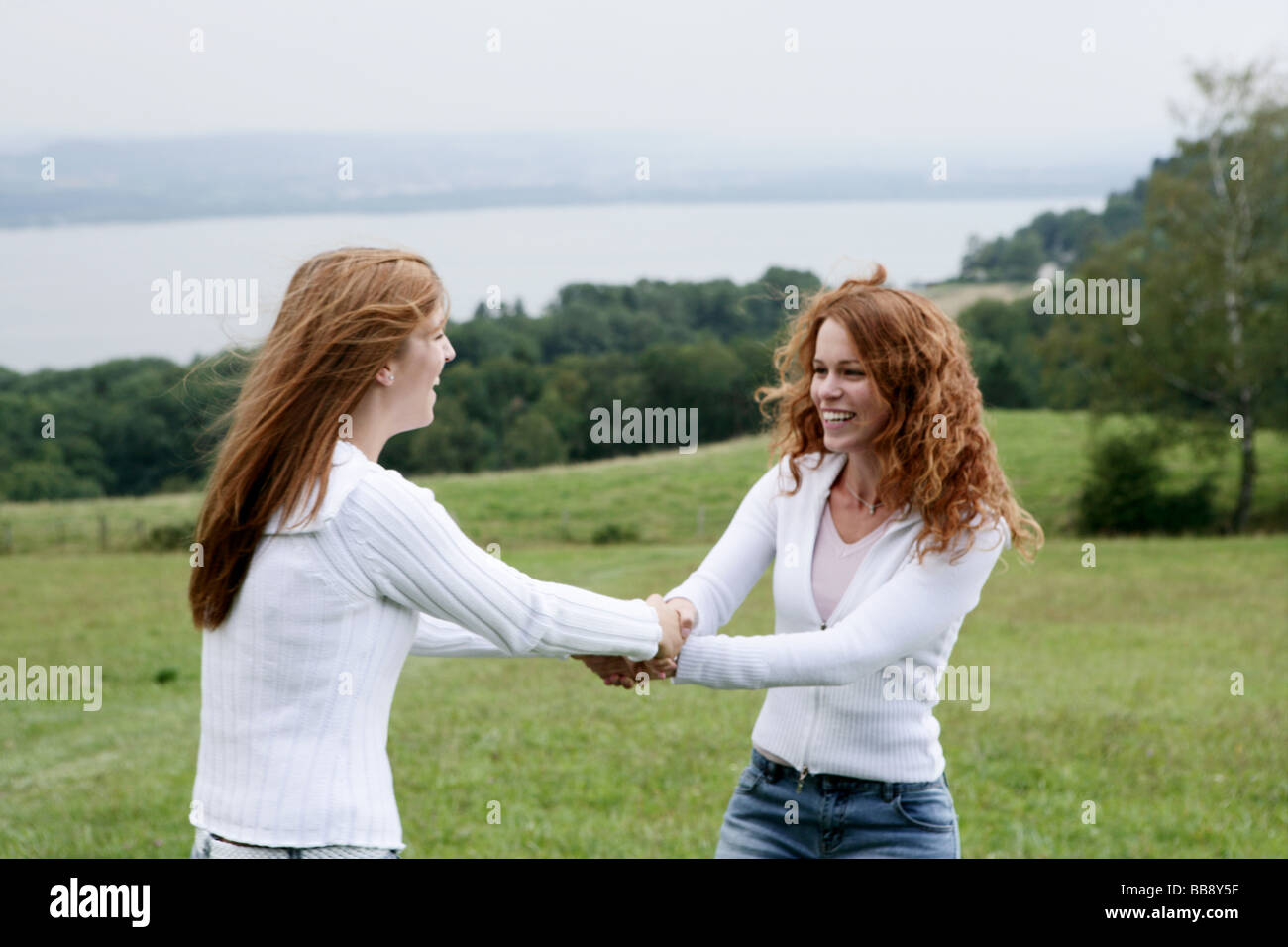 Two teenagers dancing on a field with lake view Stock Photo - Alamy