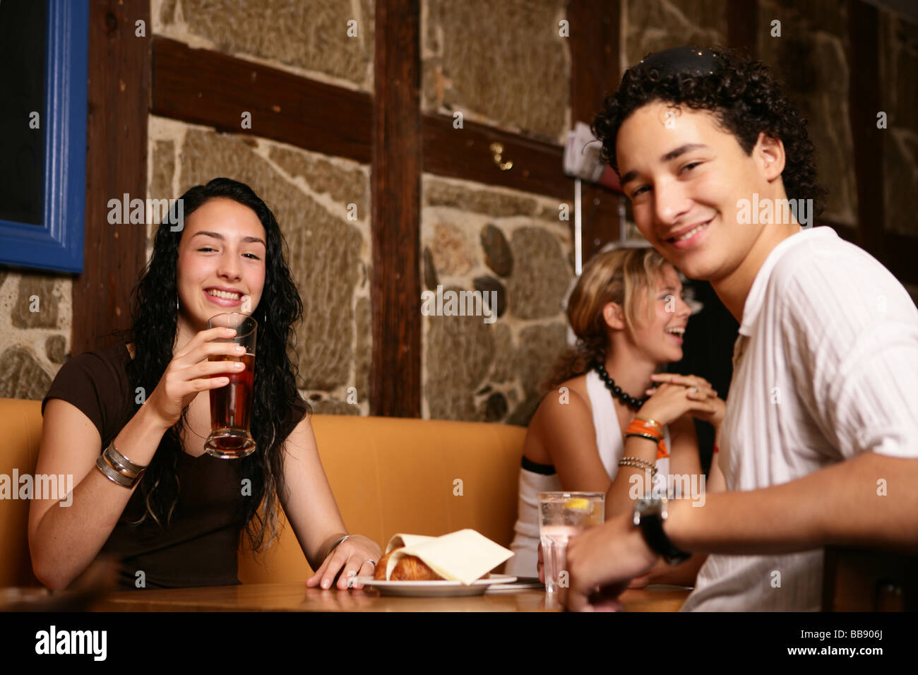 three teenager smiling in a restaurant Stock Photo - Alamy