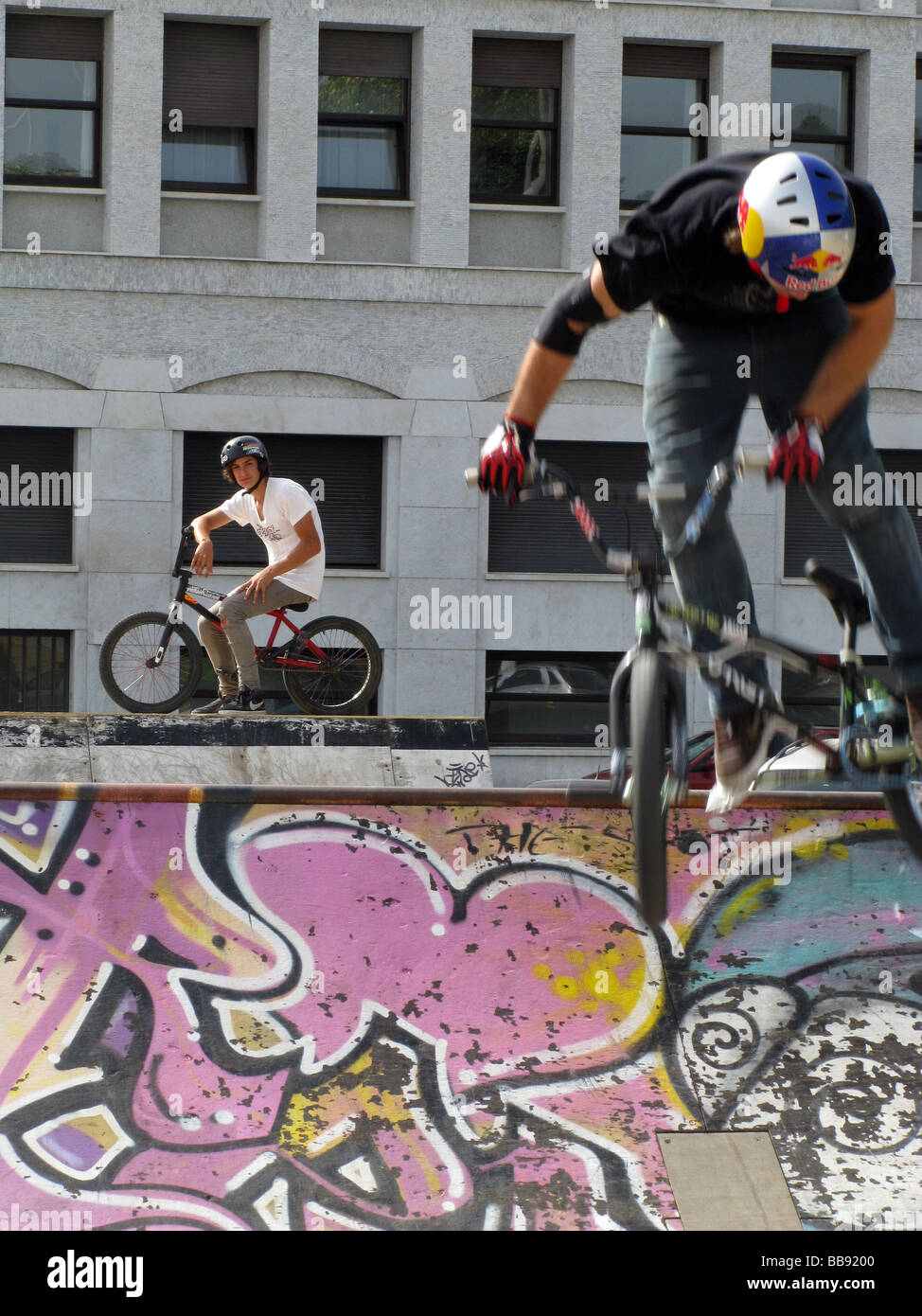 two people doing bike stunts on ramp at event outdoors Stock Photo - Alamy