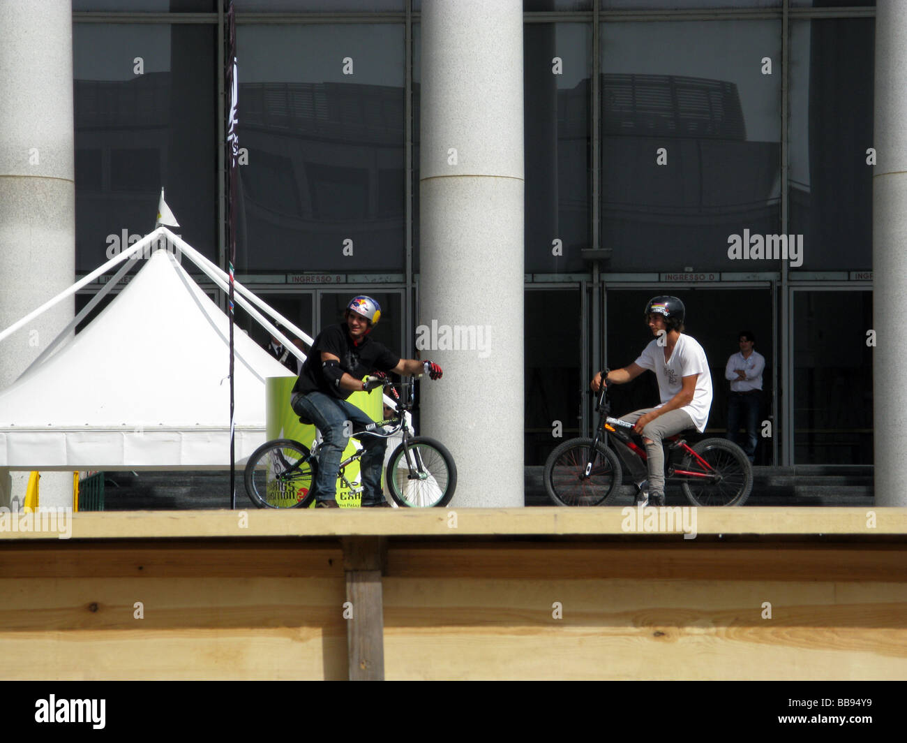 two people doing bike stunts on ramp at event outdoors Stock Photo - Alamy
