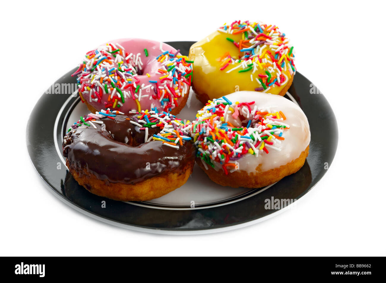 Junk food doughnuts iced on a plate Stock Photo - Alamy