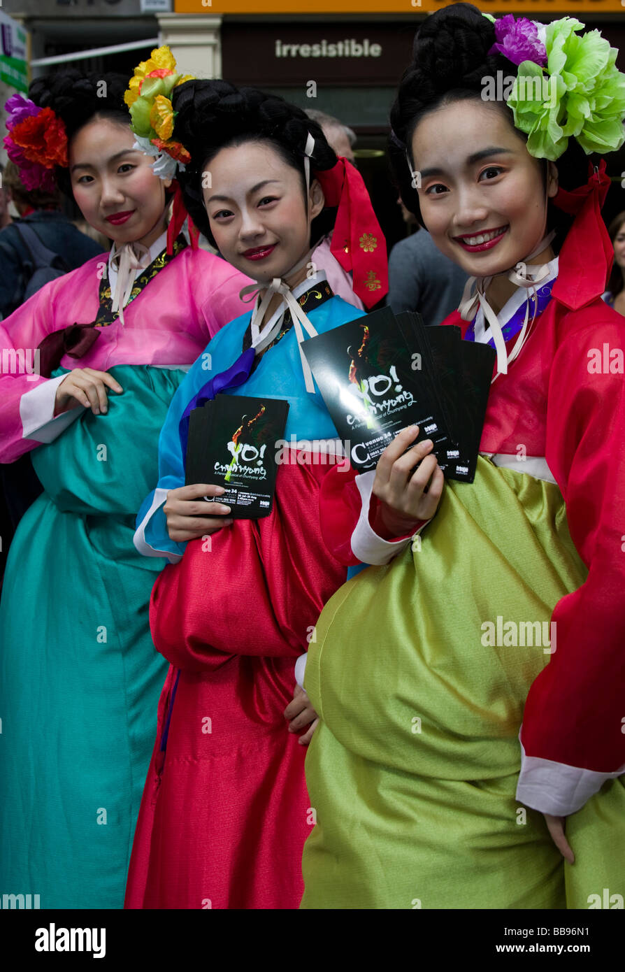 Three colourful Eastern asian female performers promote their show ...