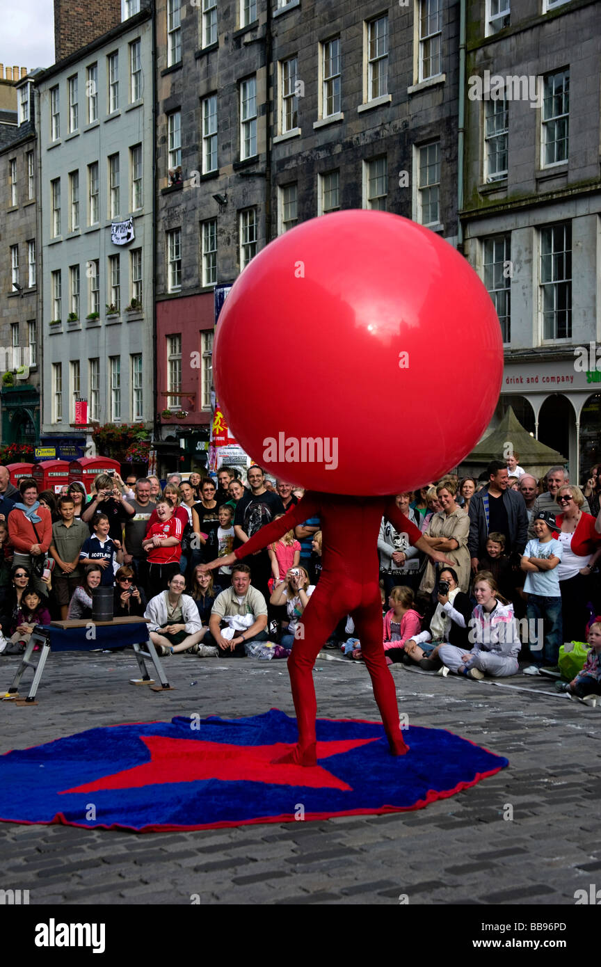 Street Performer entertains audience by getting inside inflated red ...