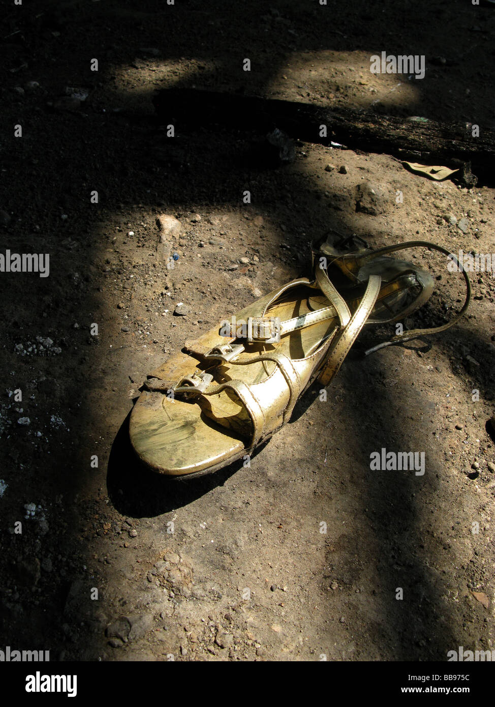 one woman's golden shoe left on derelict ground outdoors Stock Photo ...