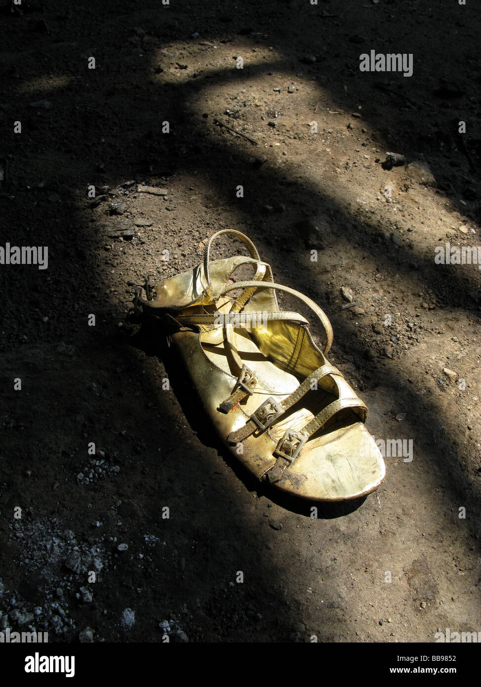 one woman's golden shoe left on derelict ground outdoors Stock Photo ...
