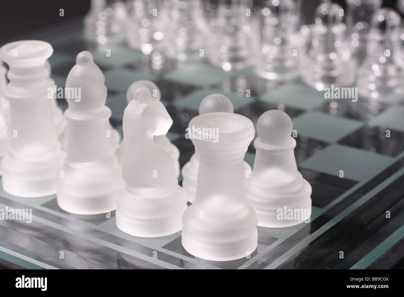 Glass chess board and pieces, against a black background Stock Photo ...