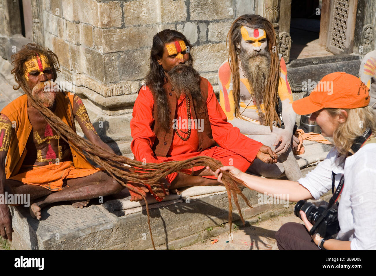 A tourist checks out the beard of a sadhu at Pashupatinath temple Stock ...