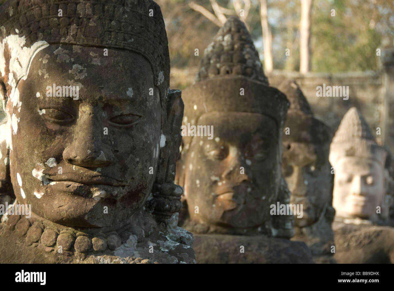 Stone demon faces on the naga bridge at the south gate of Angkor Thom ...
