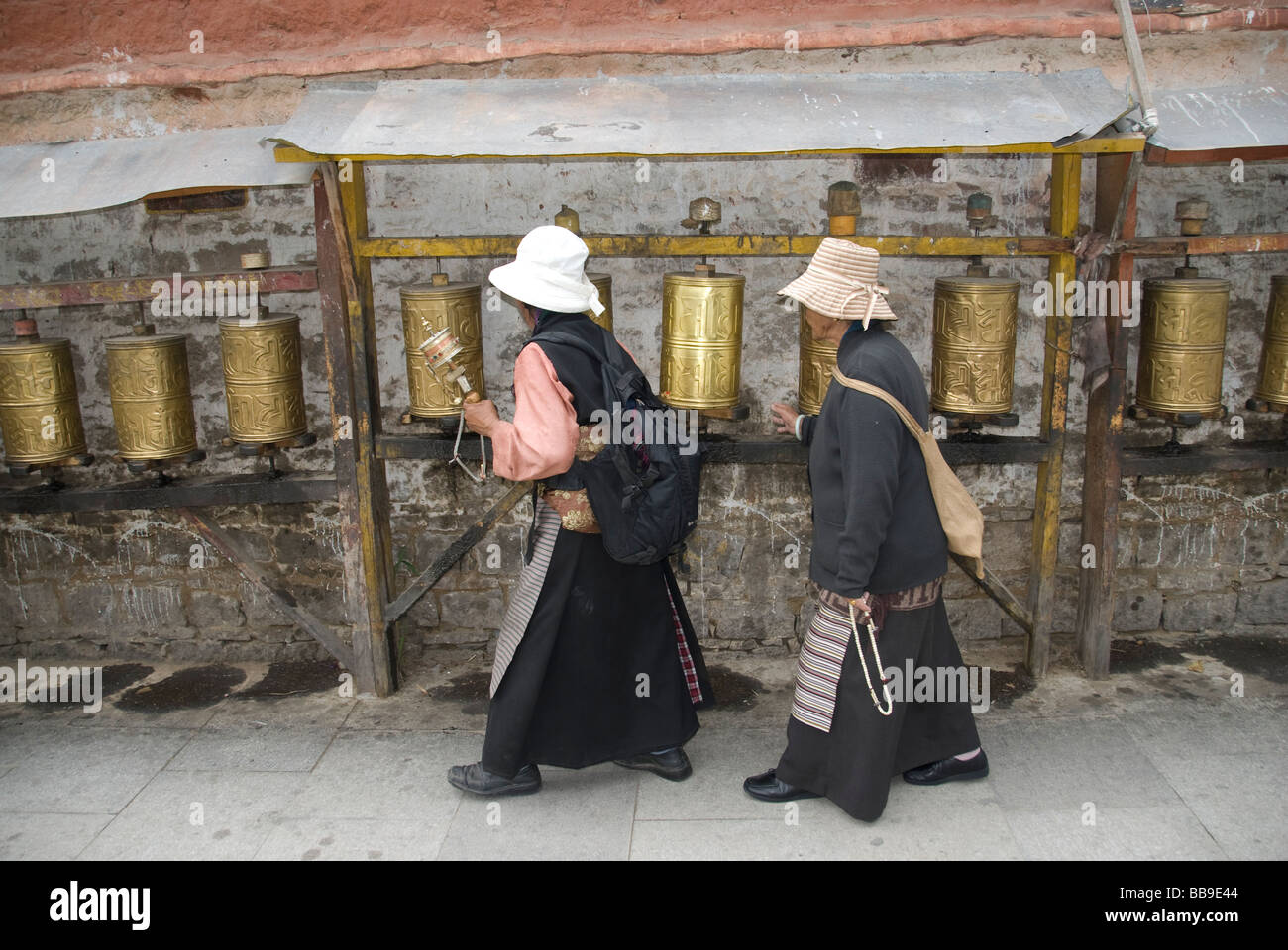 Tibetan pilgrims spinning prayer wheels on the kora surrounding the ...