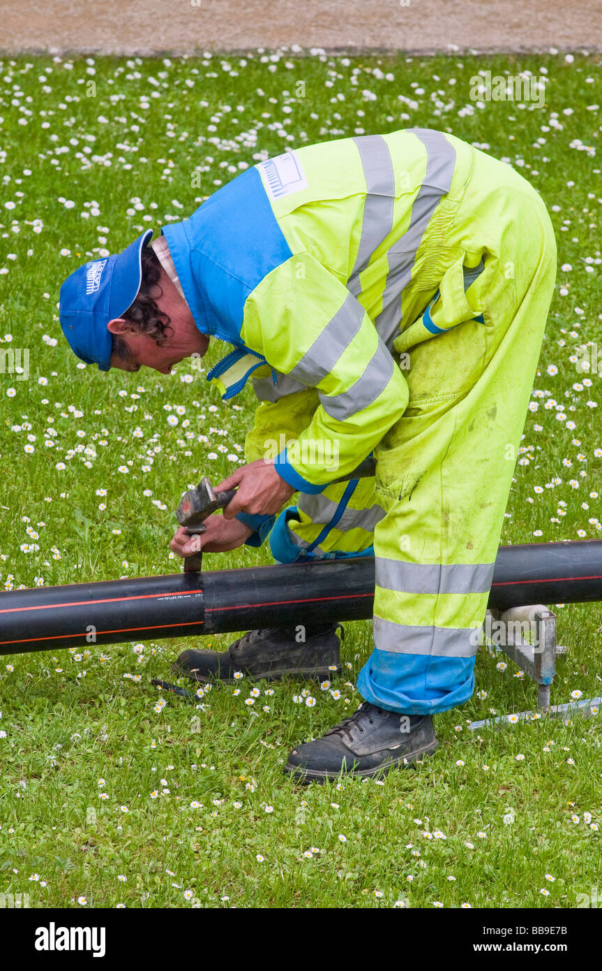 Contractor removing flash from newly heat-weld joined flexible conduit ...