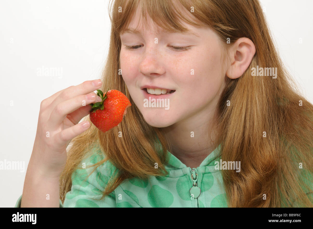 Girl eating a strawberry Stock Photo - Alamy