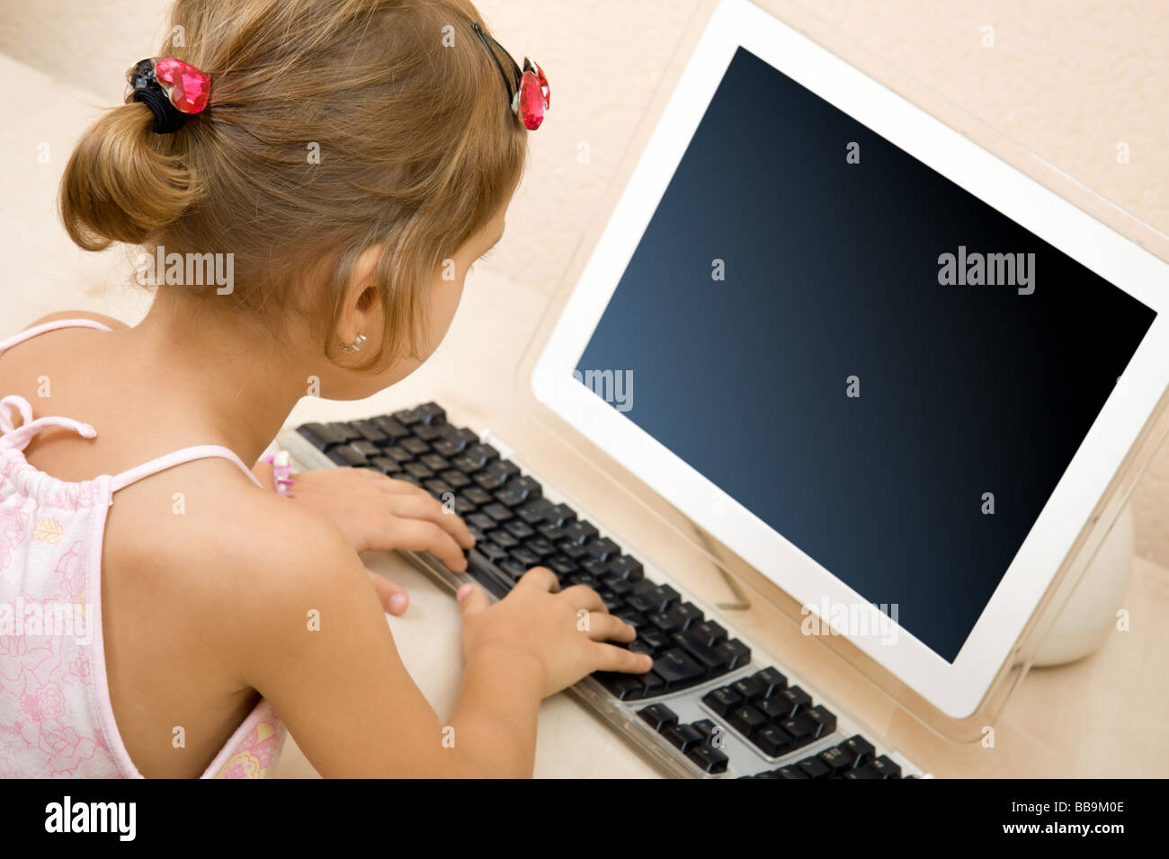Little girl typing text at the home computer Stock Photo - Alamy