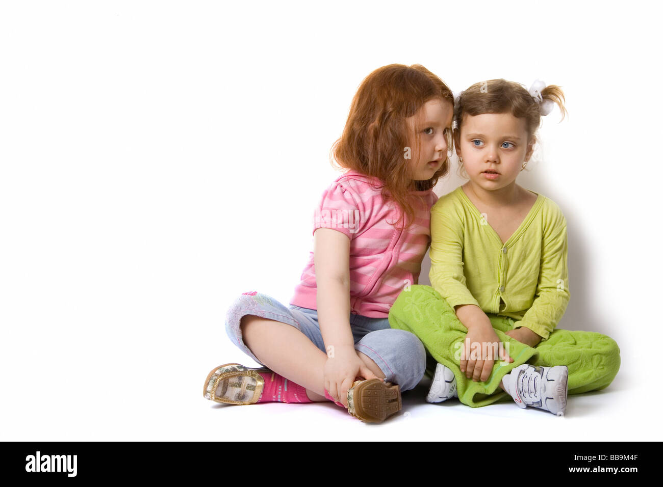 Two little girls talking in whispers Stock Photo - Alamy