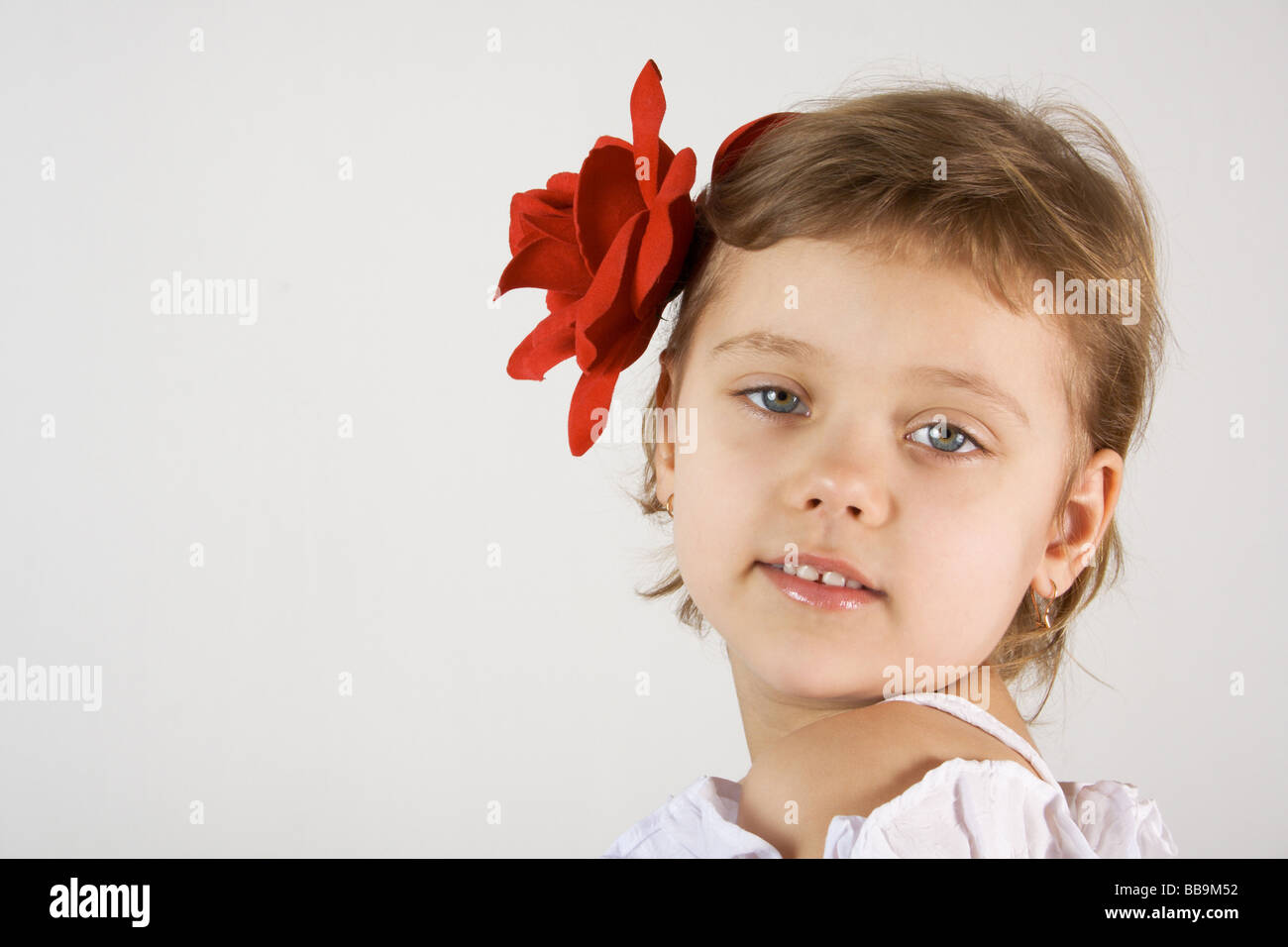 Little girl with red rouses in the hair Stock Photo - Alamy