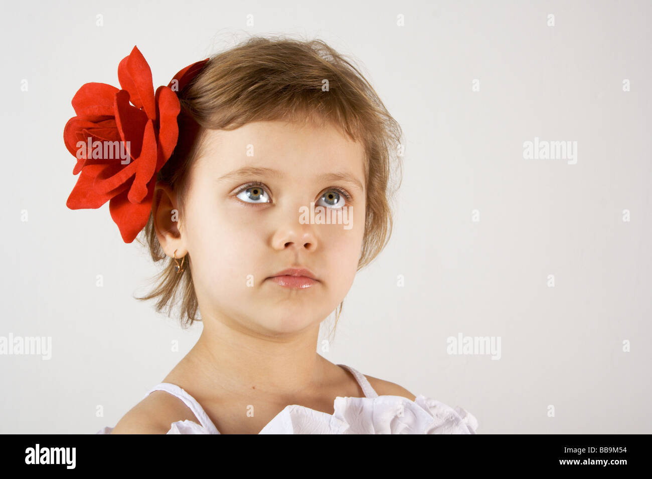 Little girl with red rouses in the hair Stock Photo - Alamy