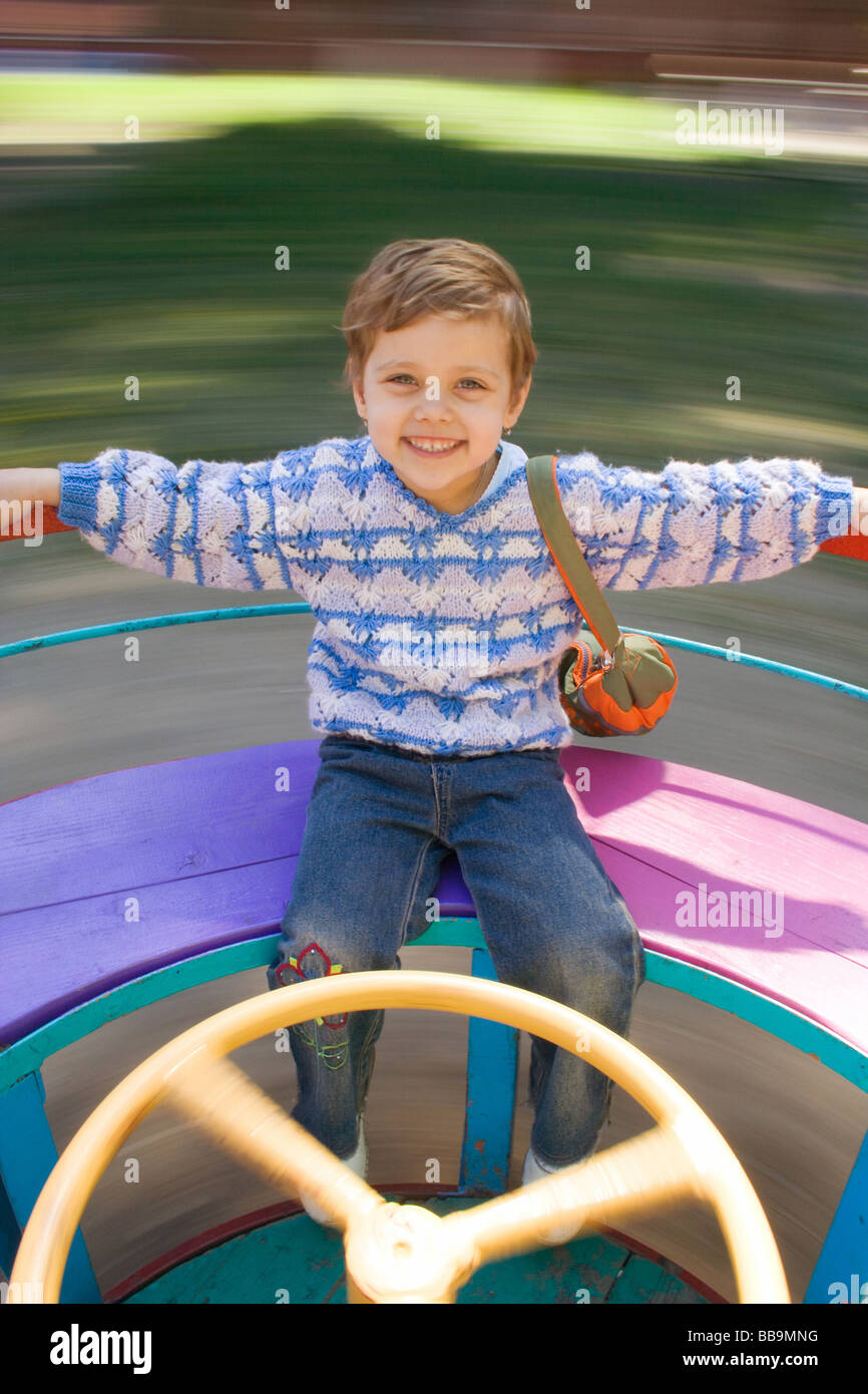 The happy little girl is turned on a roundabout Stock Photo - Alamy