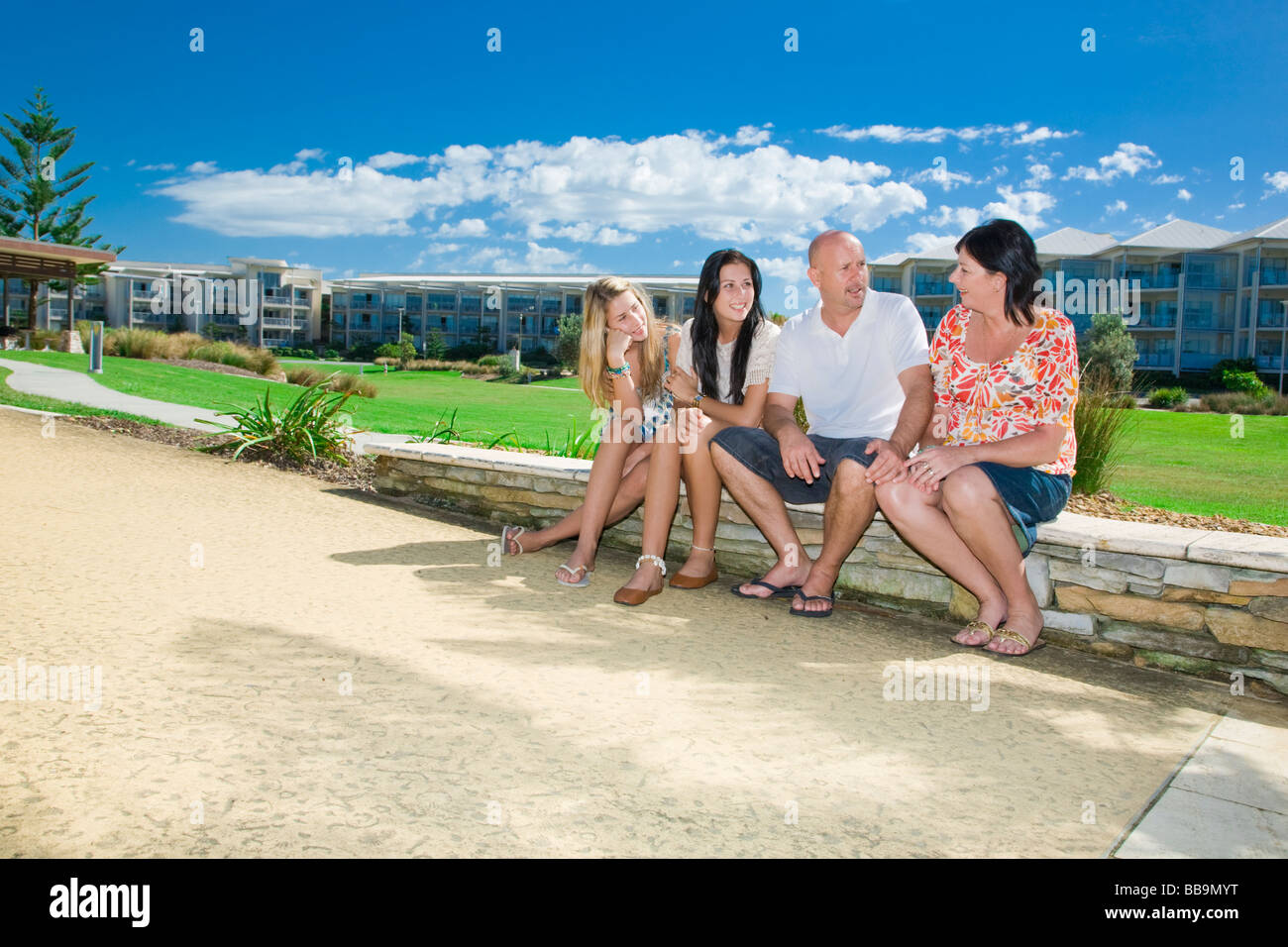 family sitting in park talking together Stock Photo - Alamy