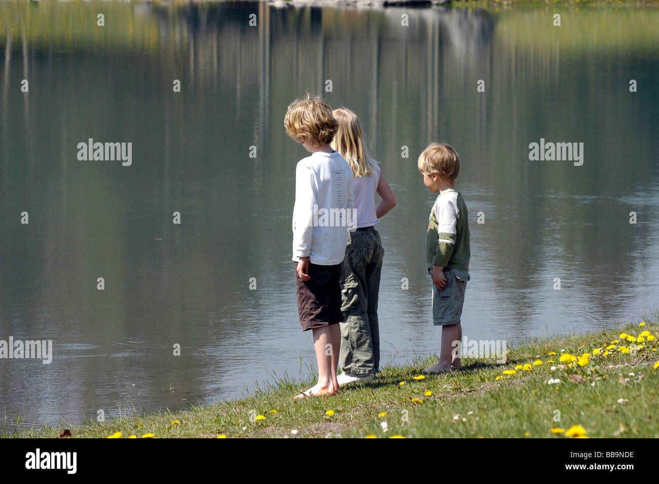 Three children play in a lake in Samoens France Stock Photo - Alamy