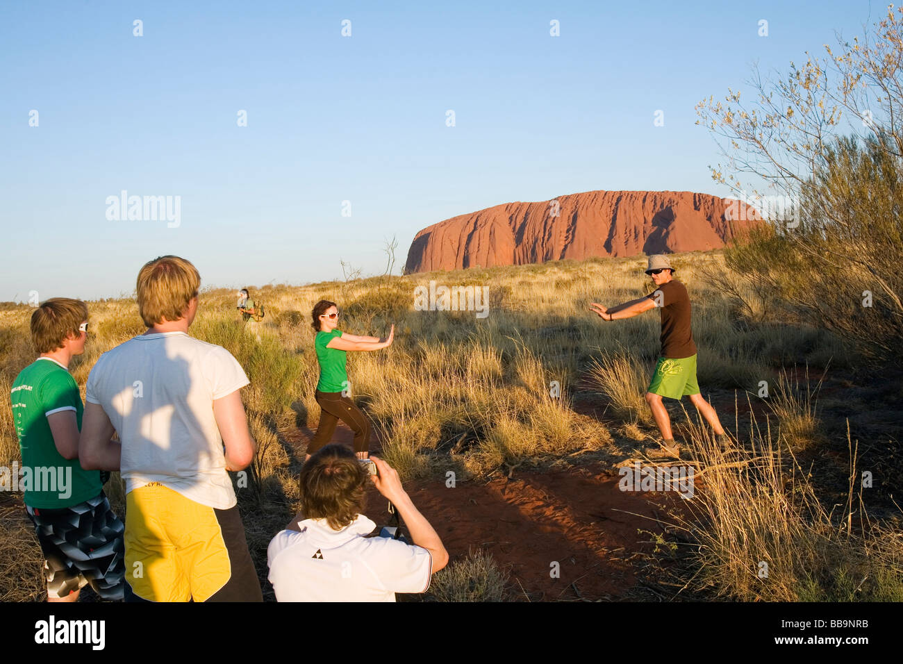 Tourists photo fun at Uluru (Ayers Rock). Uluru-Kata Tjuta National ...