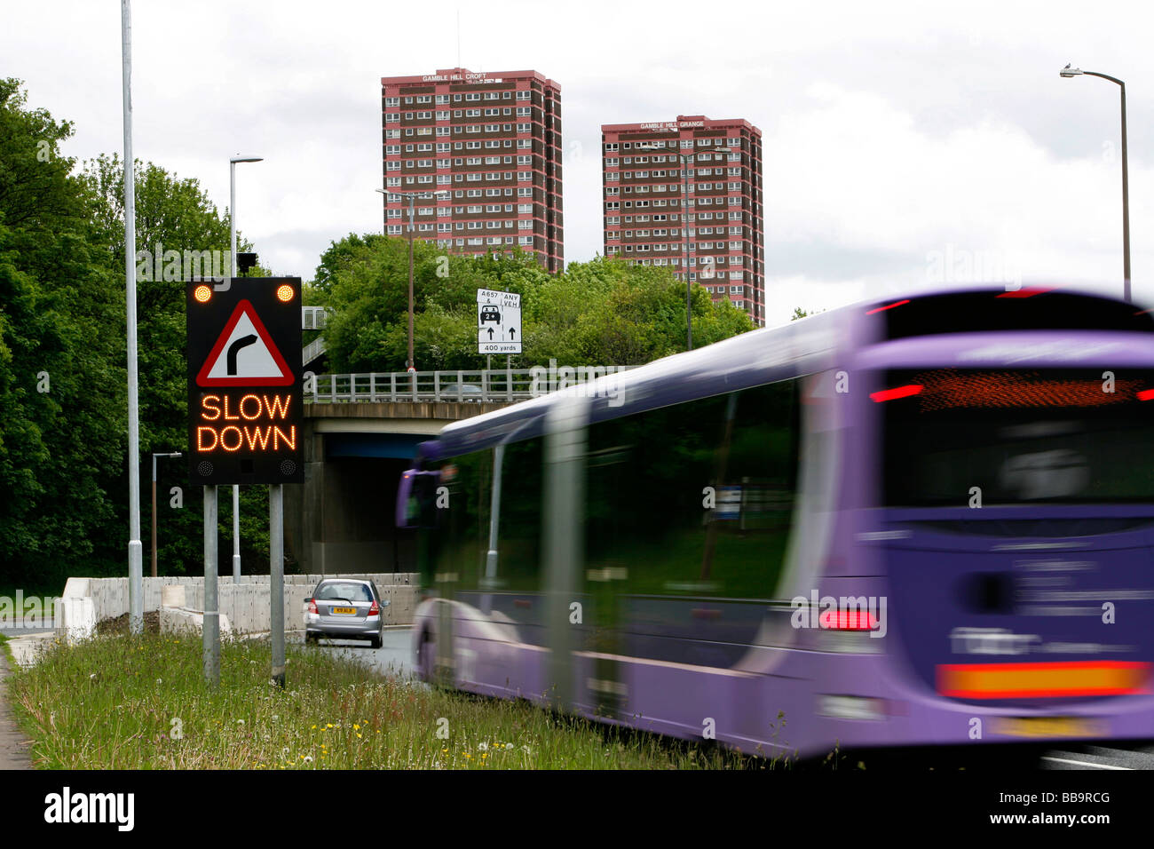 Electronic "slow down" road sign indicating a bend in the road to the ...
