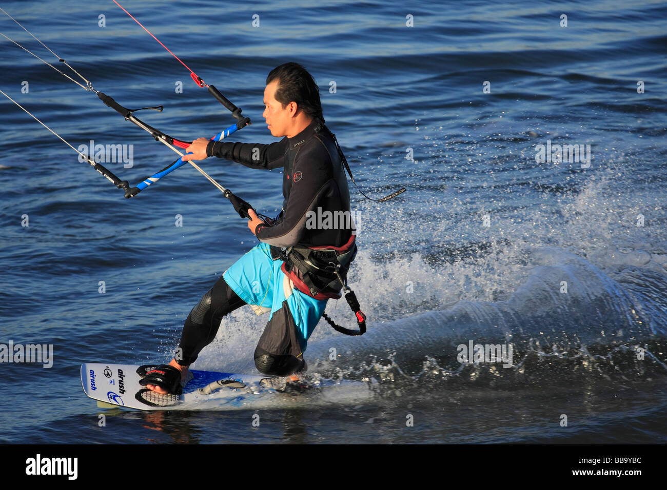 Kite Surfing. Kite Surfer creating huge wake as they move quickly atop ...