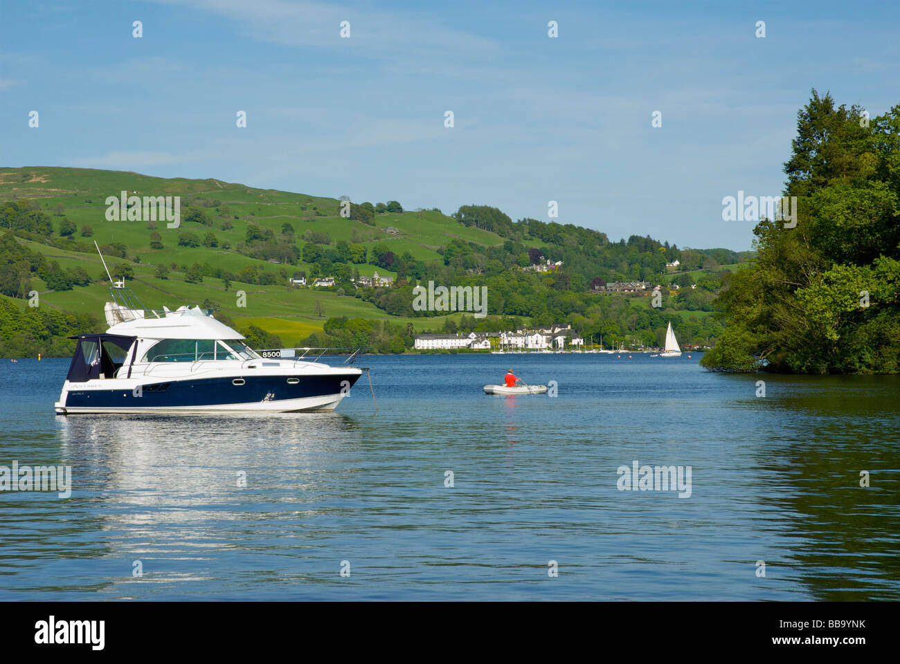 Man rowing inflatable dinghy to cruiser, moored in Pullwood Bay, Lake ...