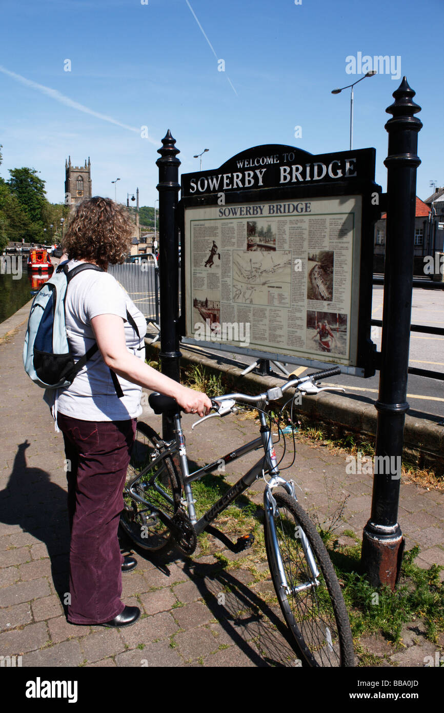 A cyclist looking at a map of the Rochdale Canal at Sowerby Bridge in ...