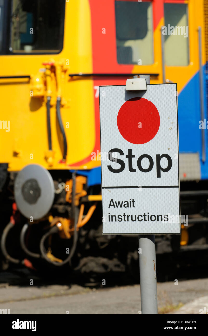Stop await instructions sign alongside railway track Stock Photo - Alamy