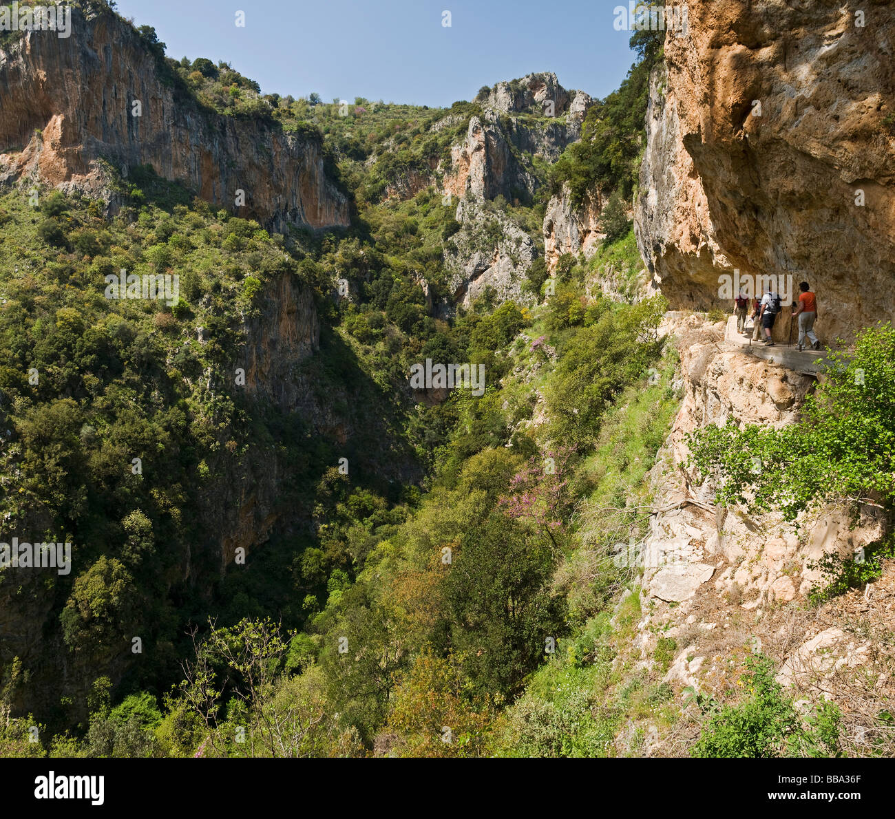 Walkers on a narrow path in the Apothetes ravine, Langadhiotissa gorge ...