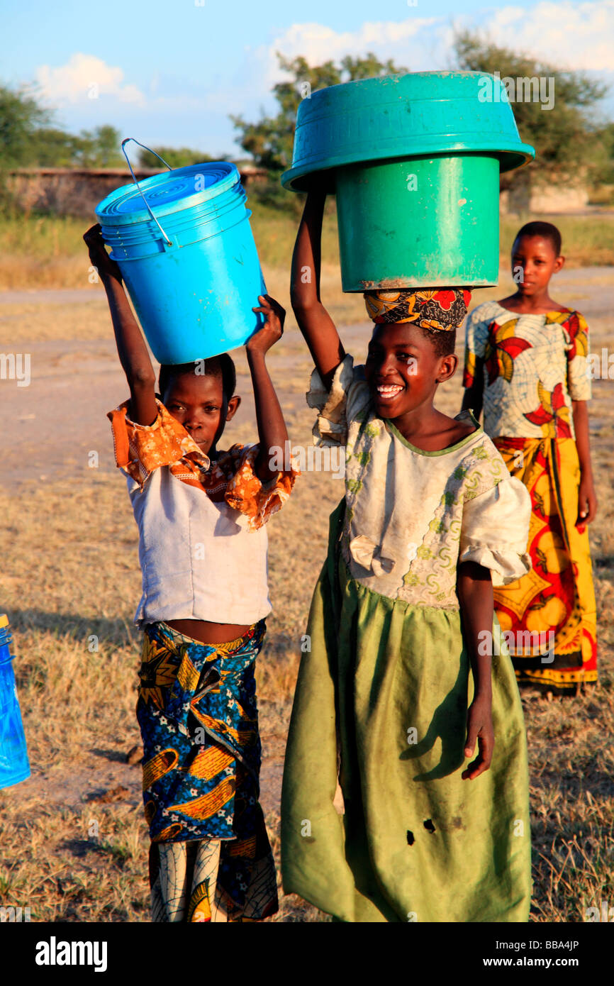 Village children with water buckets on their heads Stock Photo - Alamy