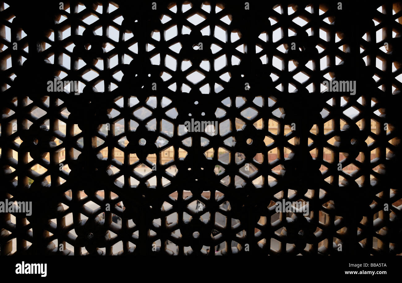 A marble window screen pierced with various irregular shapes. Amber ...