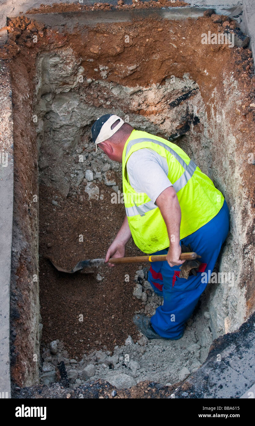 Road works contractor digging at bottom of excavated pit - France Stock ...
