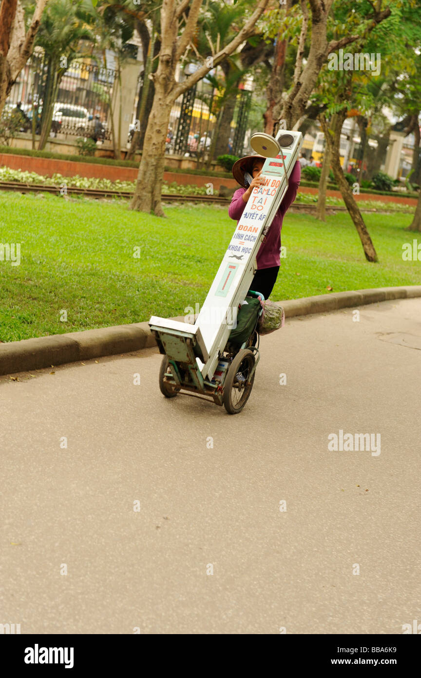 vietnamese old lady pushing scale machine around Lenin park for people ...