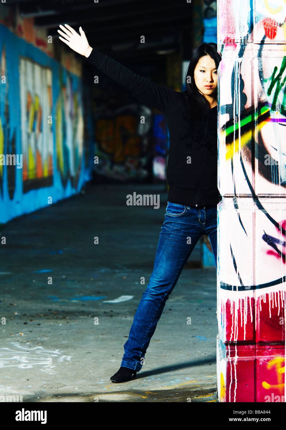 Young Asian girl in rapper pose between walls with graffiti Stock Photo ...