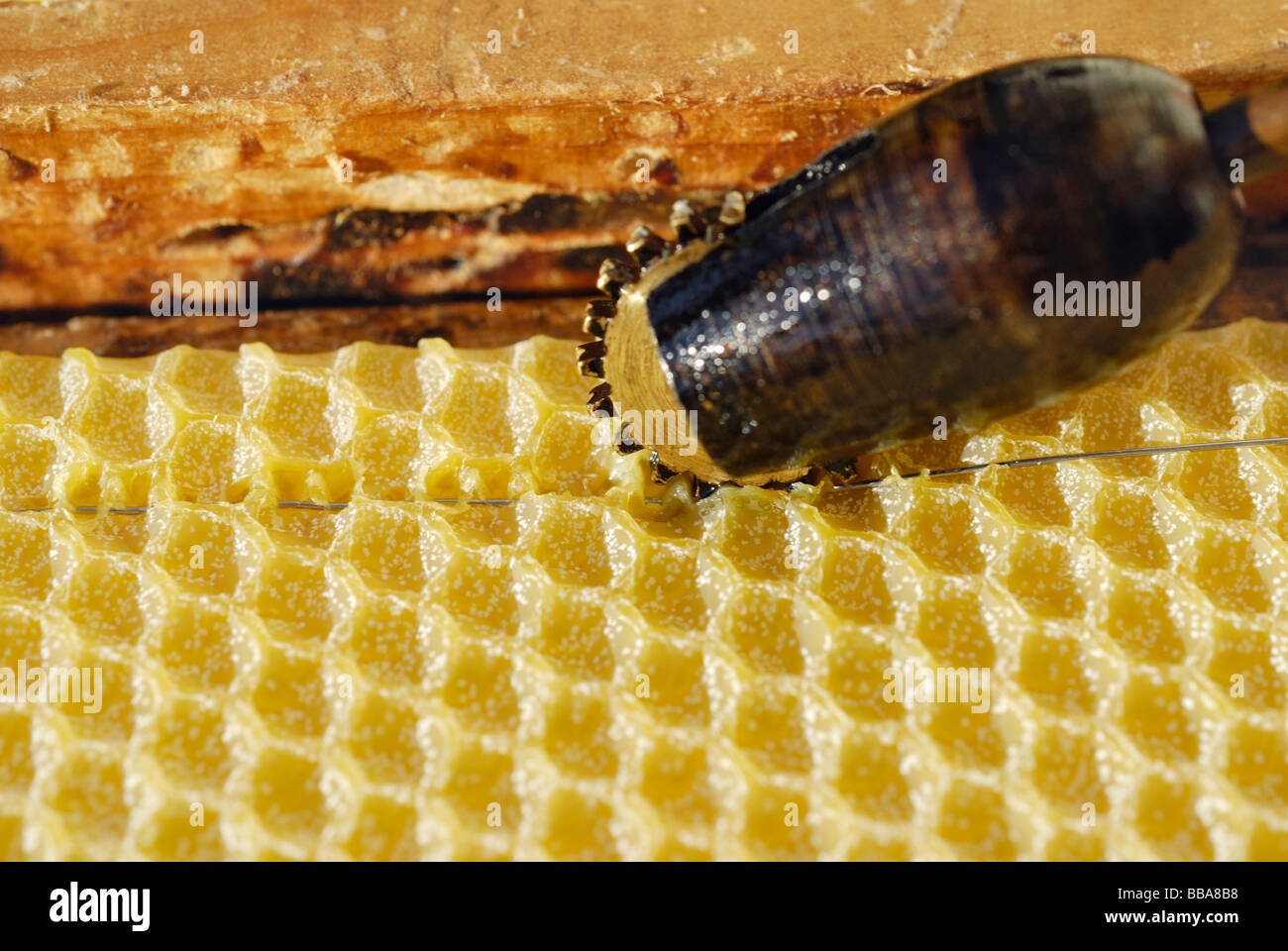 A honeycomb base is soldered onto wires in a honeycomb frame with a ...