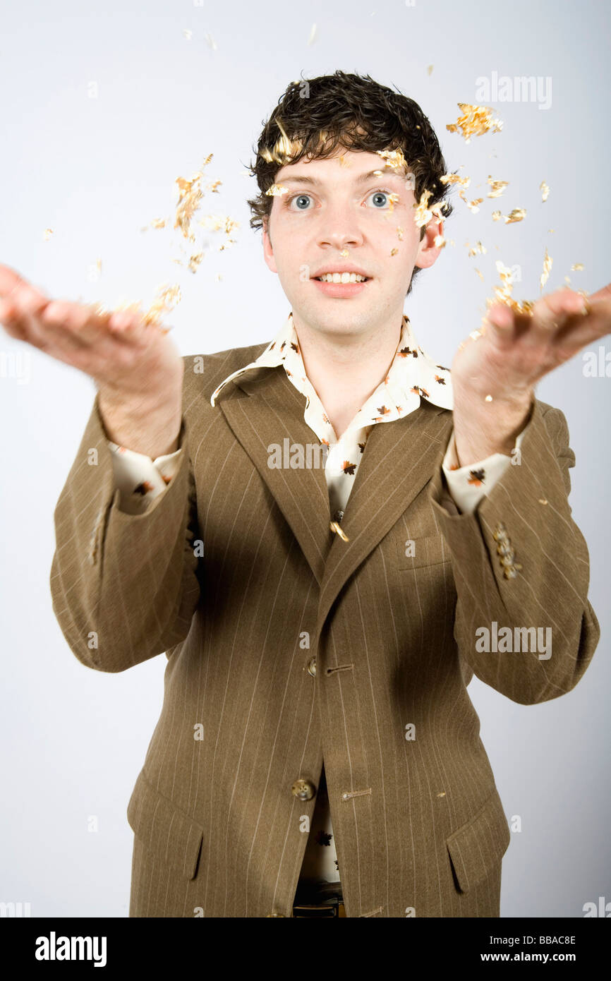 A young man tossing gold foil in the air Stock Photo - Alamy