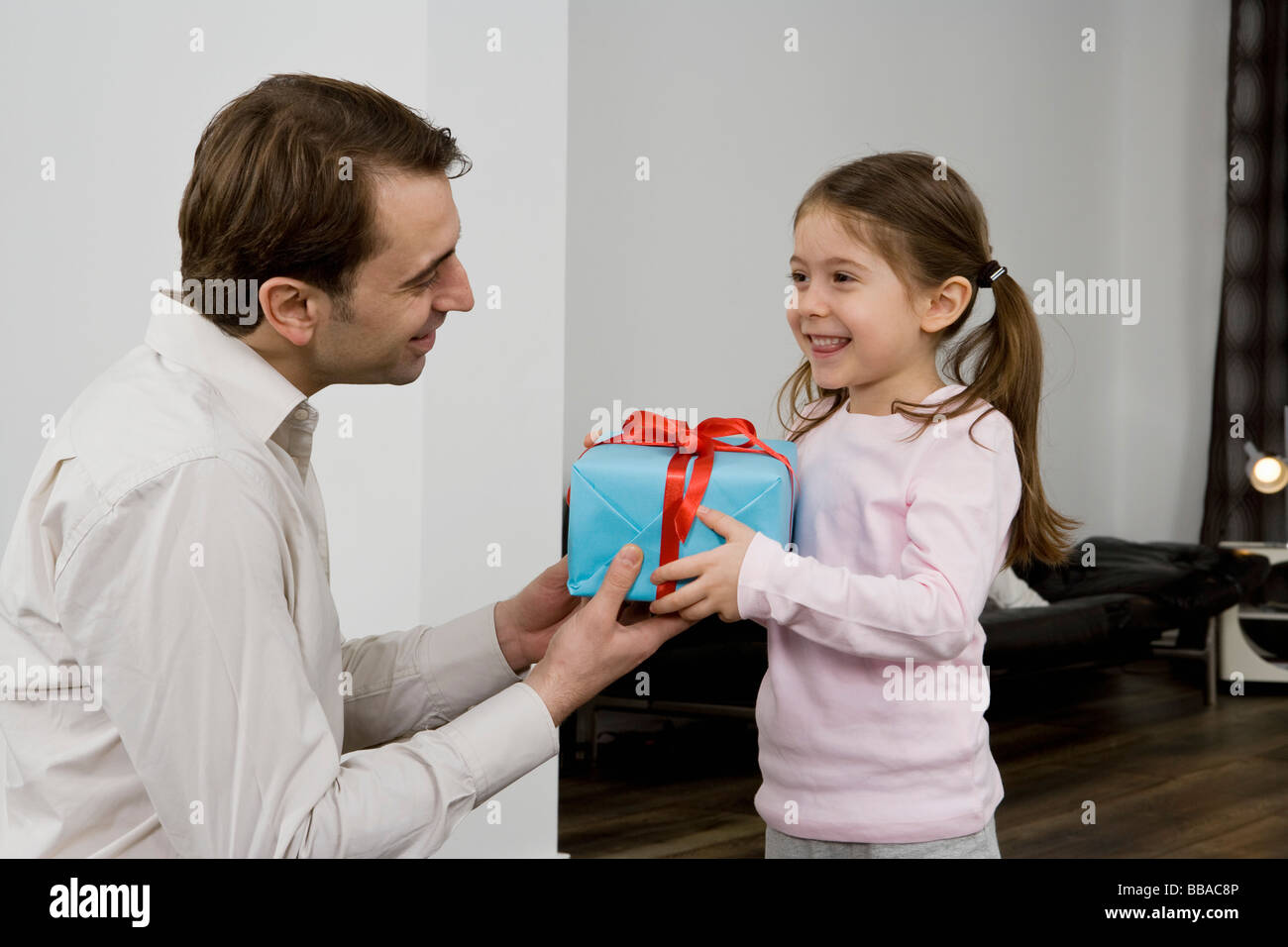 A father giving his daughter a present Stock Photo - Alamy