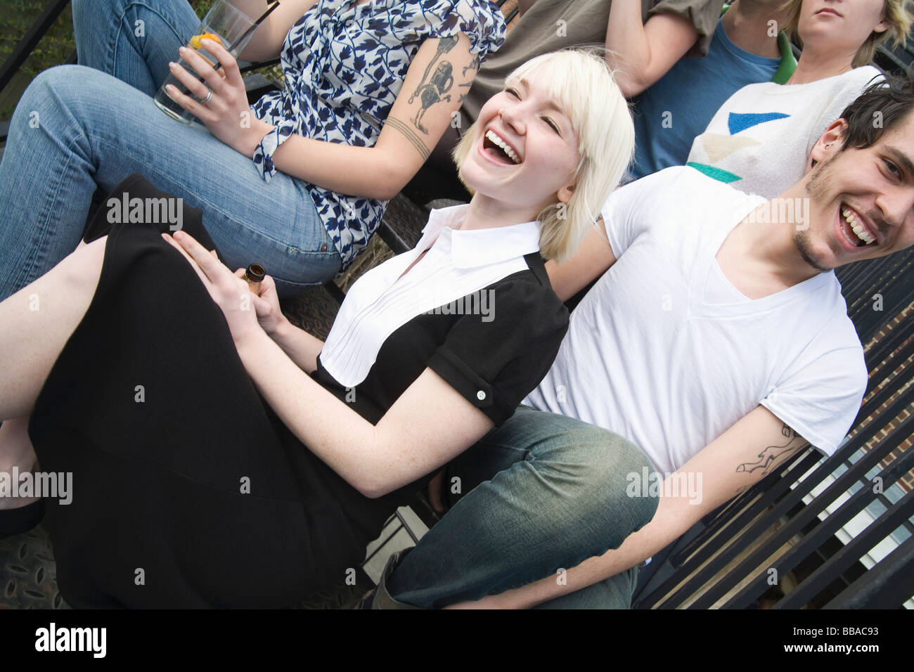 A group of friends sitting on a roof top together Stock Photo - Alamy