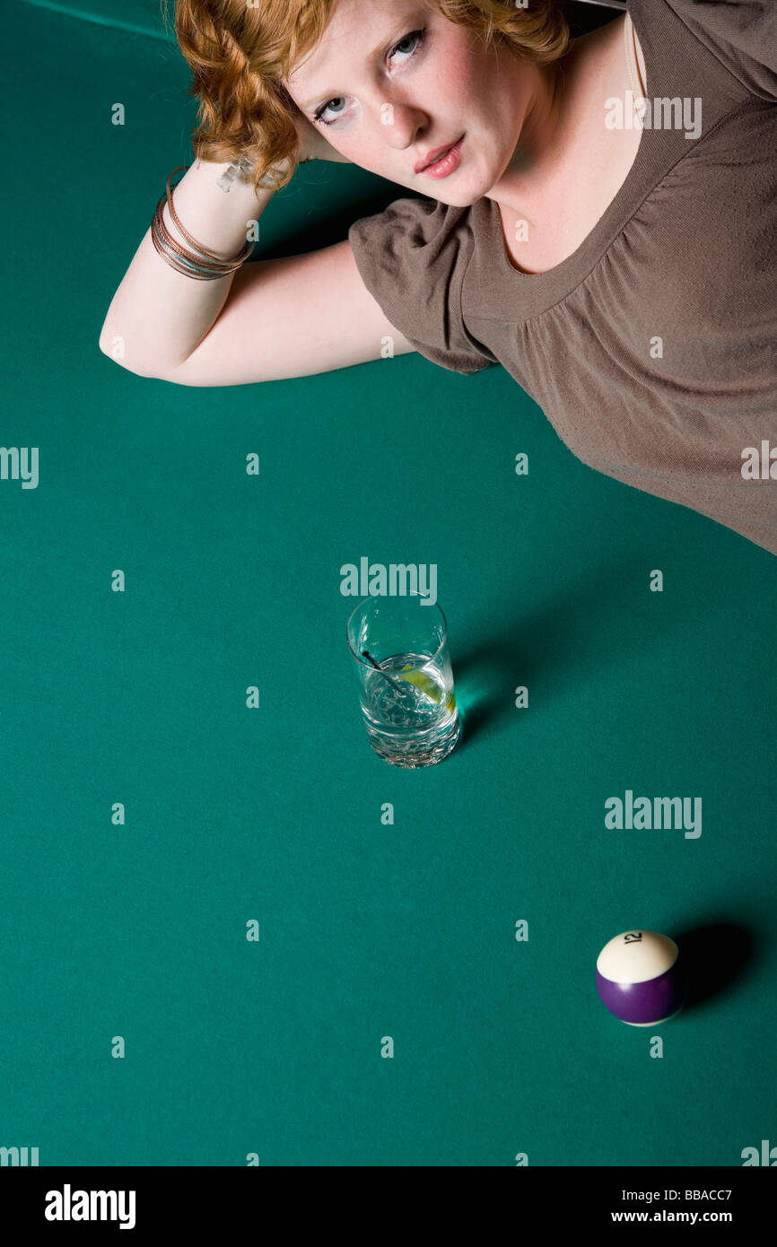 A young woman lying down on a pool table Stock Photo - Alamy