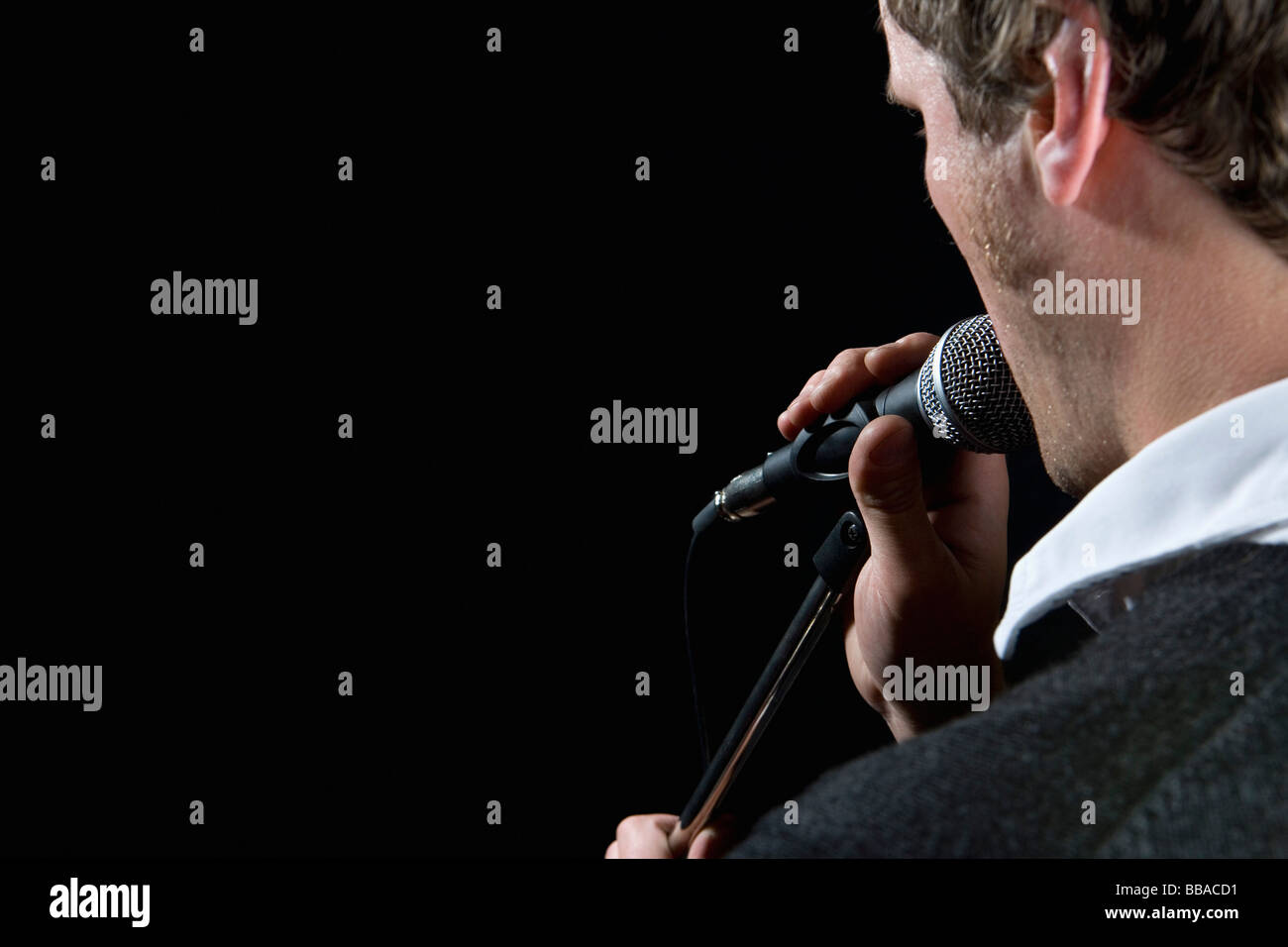 Rear view of a man singing into a microphone Stock Photo - Alamy