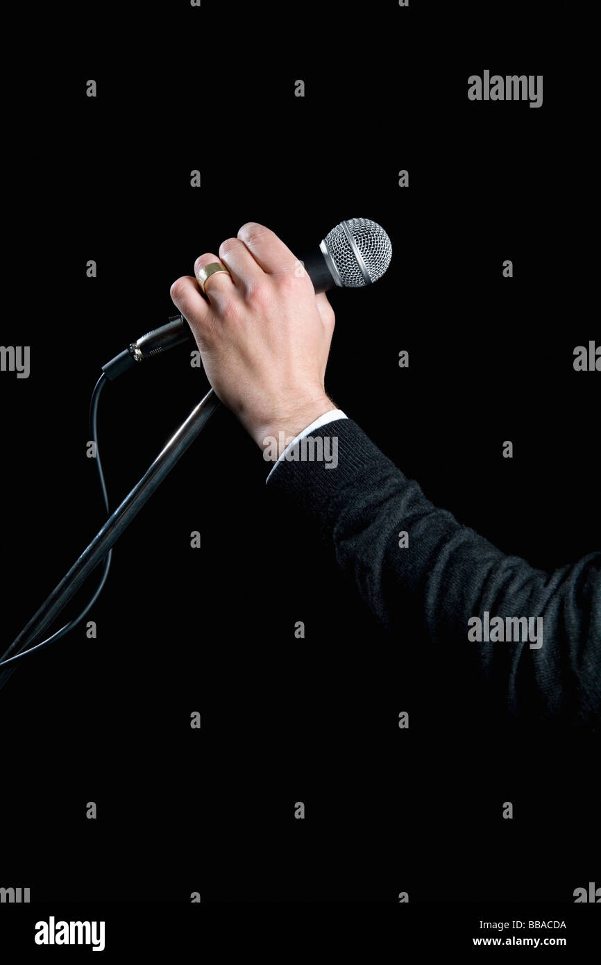 Detail of a man holding a microphone Stock Photo - Alamy