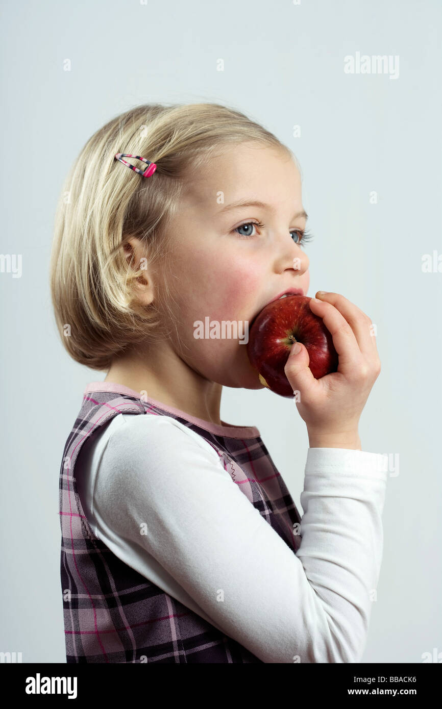 A young girl eating an apple Stock Photo - Alamy