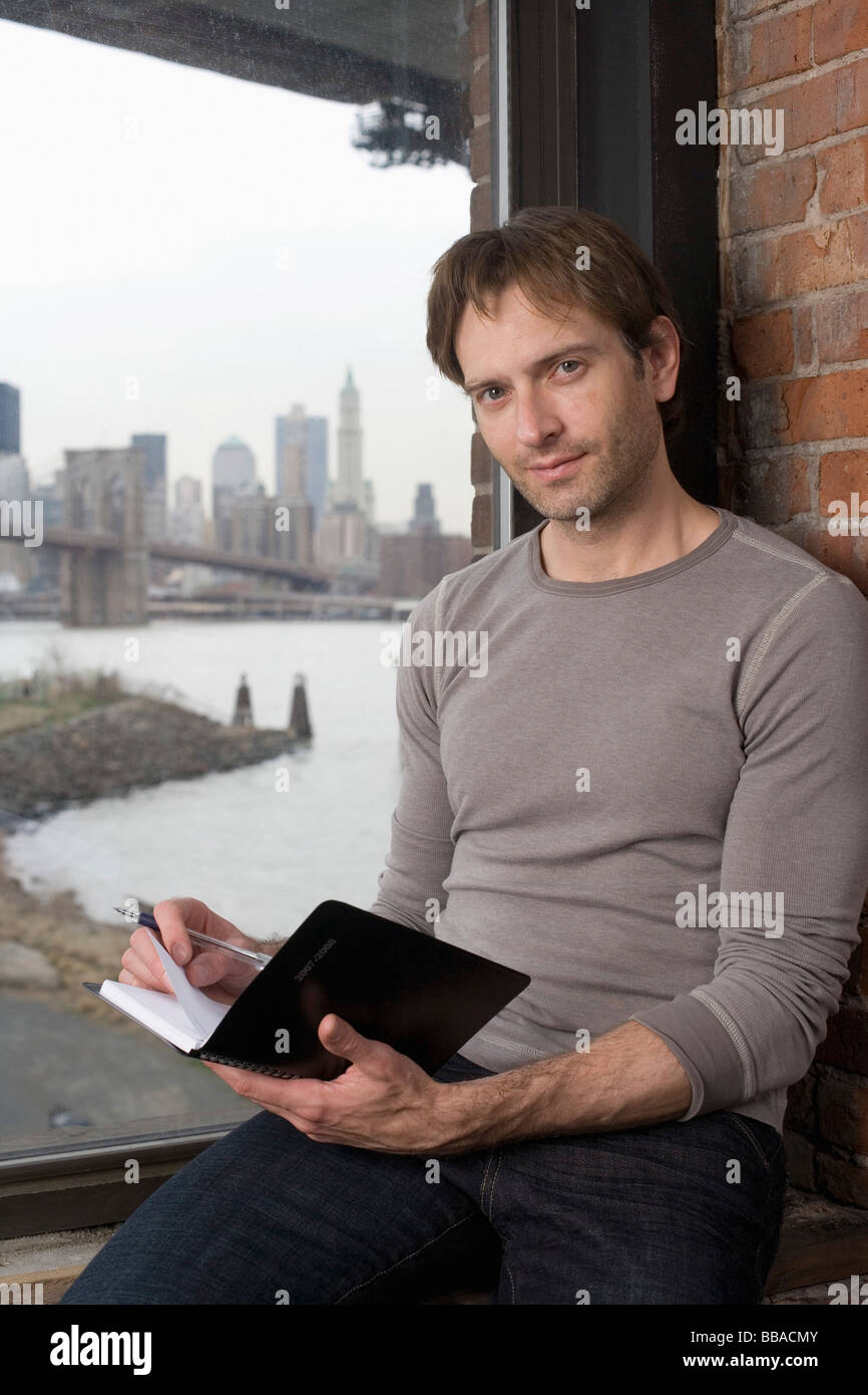 Man sitting on a window sill Stock Photo - Alamy