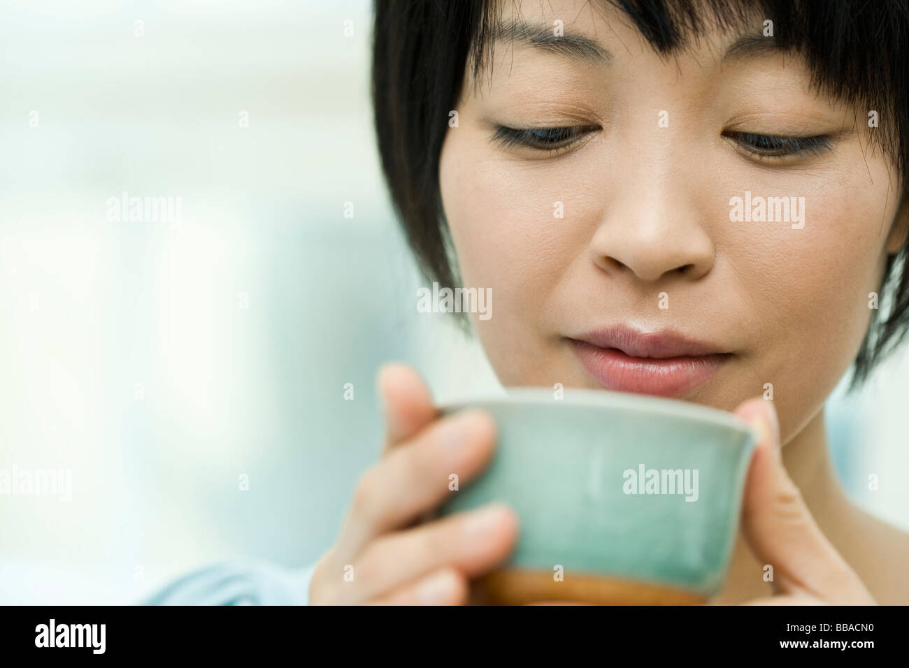 A woman drinking from a tea cup Stock Photo - Alamy