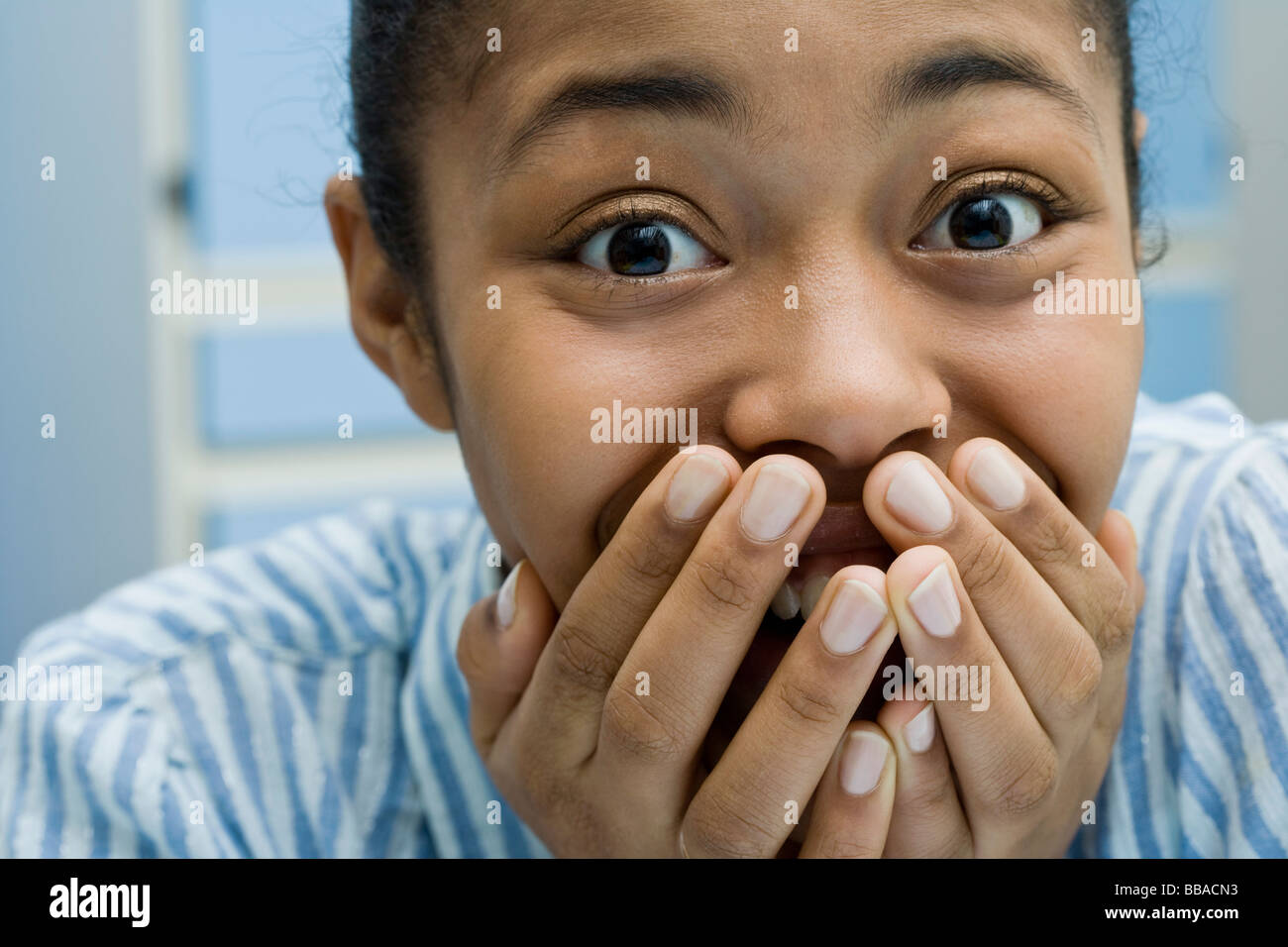 A young woman covering her mouth and laughing Stock Photo - Alamy
