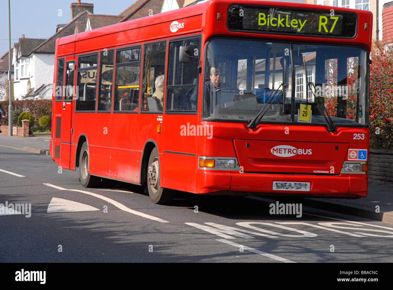 Single deck red bus on speed hump Stock Photo - Alamy