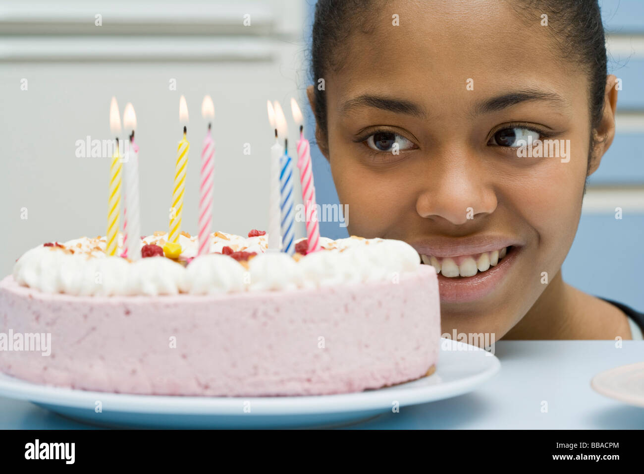 A young woman looking at a birthday cake Stock Photo - Alamy