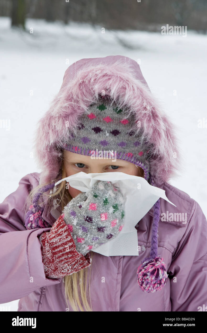 A young girl outdoors in snow blowing her nose Stock Photo - Alamy